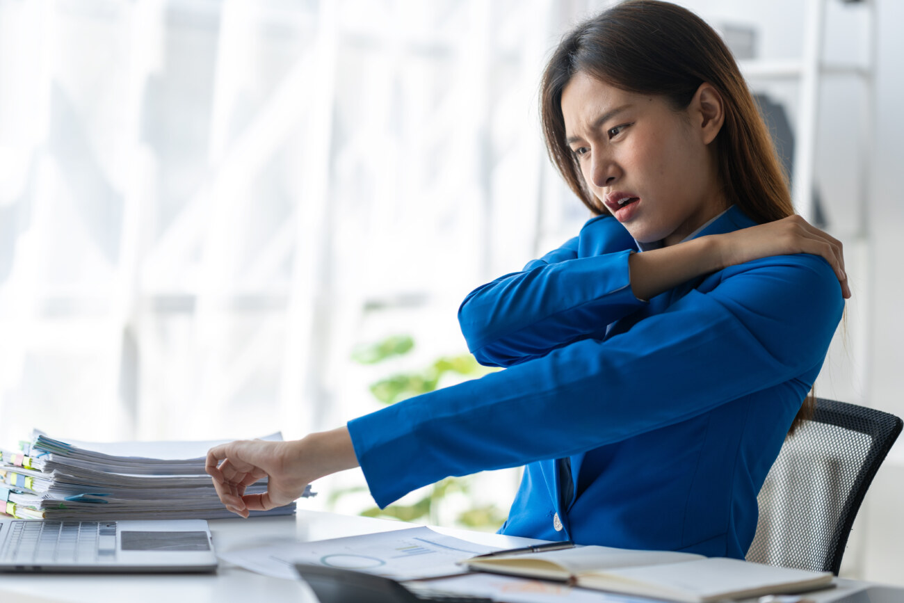 Young businesswoman having pain and fatigue in her shoulders and neck ...